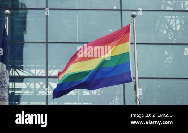 Rainbow LGBT Pride Flag Waving in Front of Modern Building Glass Facade ...