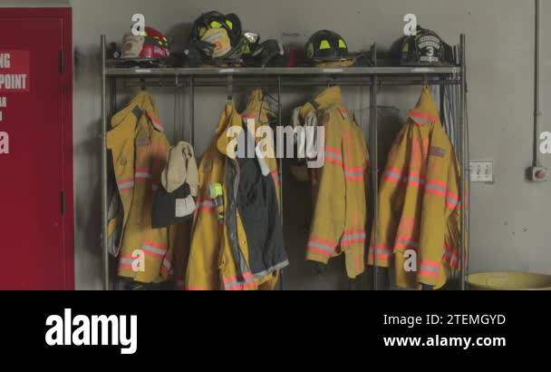 Firefighting gear hangs on a rack inside a fire station ready for ...