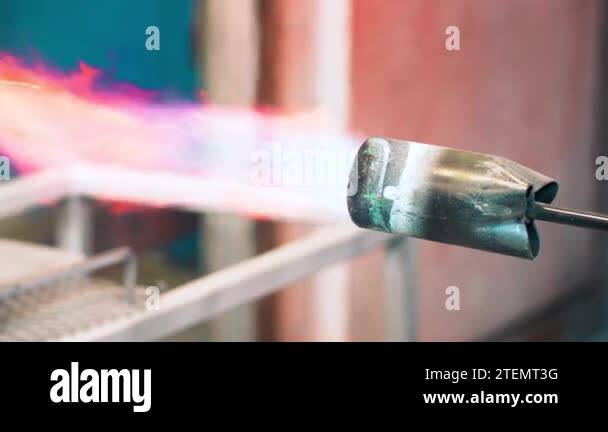 Man lighting large blow torch with a lighter which produces a fireball ...