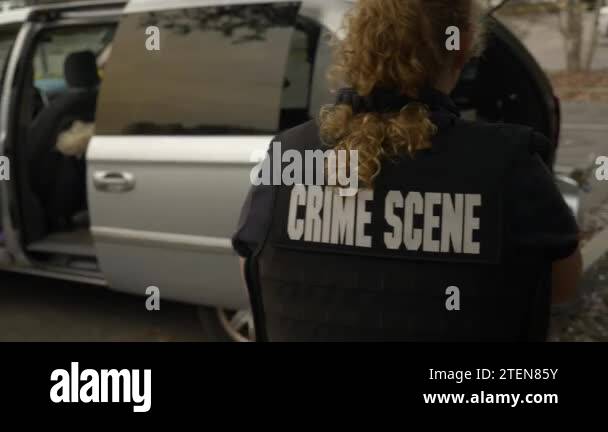 A crime scene investigator walks around and takes pictures of a crime ...