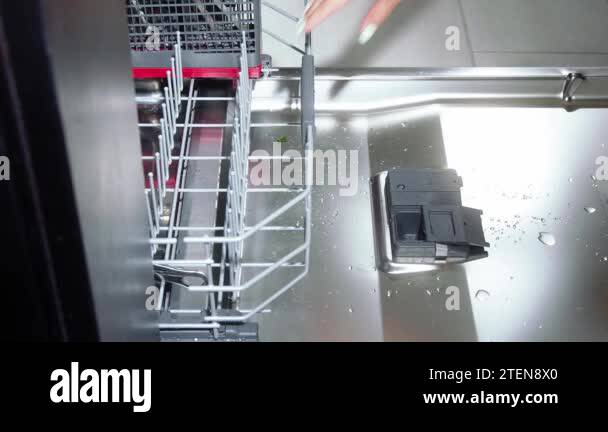 girl loading dishes into the dishwasher, dishes in dishwasher machine ...