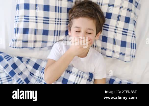 sick coughing boy kid lying in bed at home. ill child with severe cough ...