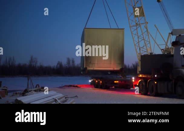 Process of unloading a truck car with a crane and metal cables in the ...