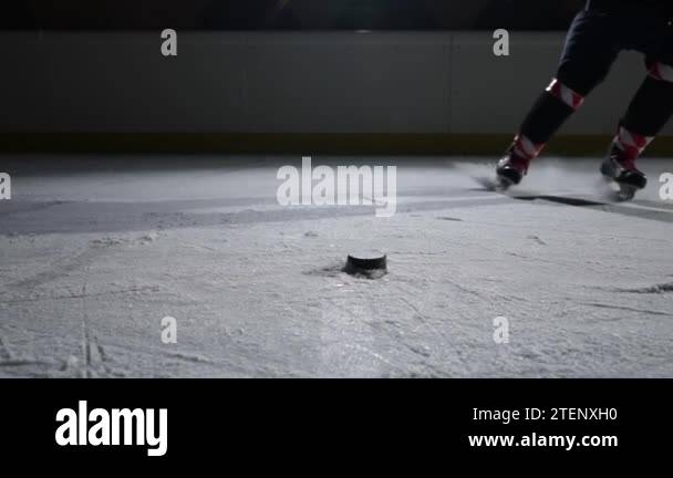 Camera following hockey player feet in skaters sliding on ice. Close up ...