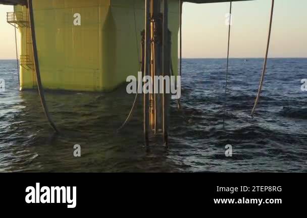 Under offshore drilling platform. Riser, pipes, hoses. Moon pool. Pipe ...