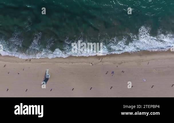 Flying over Los Angeles beach showing beach and waves crashing, moving ...