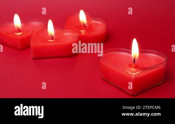 Red burning heart-shaped candles with blazing flames. Tongues of fire ...