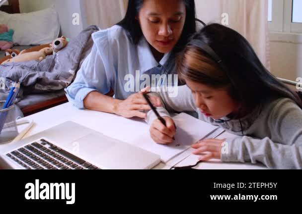 4K Asian young little girl using a laptop to study with her mother ...