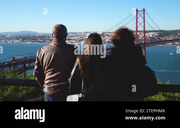 Traditional full family. Daughter with parents at bridge 25 de Abril ...