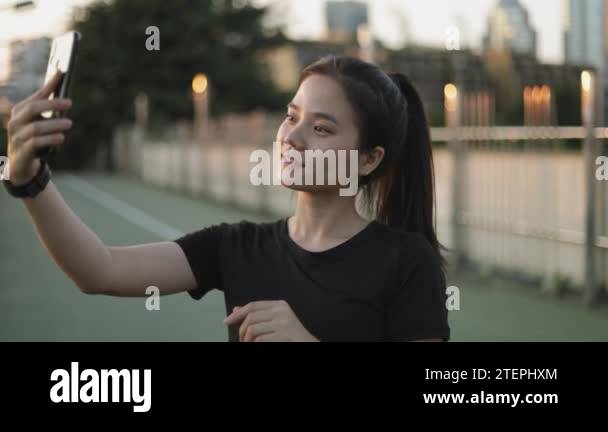Asian female athletes running using smartphones having video chat ...