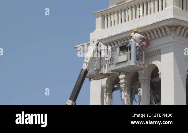 masons do maintenance work of a church with a boom lift - crane ...