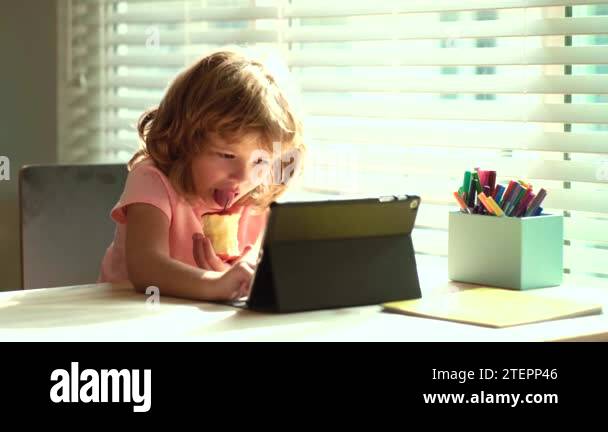 School boy working on tablet at school. Little student using modern pc ...