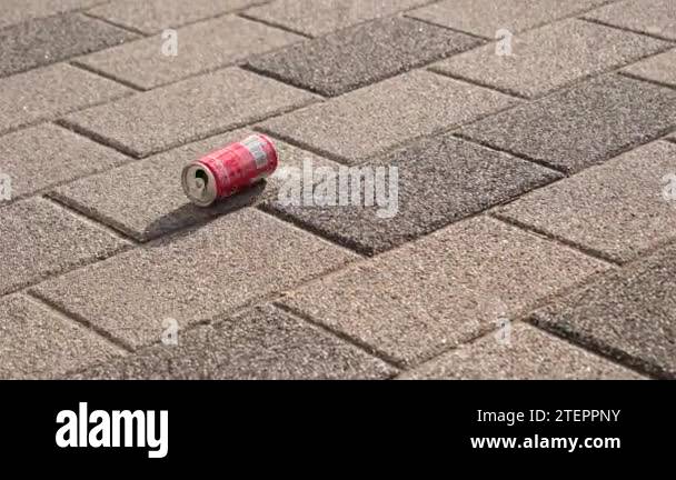 Garbage pollution - a coca cola can left as a trash on city sidewalk ...