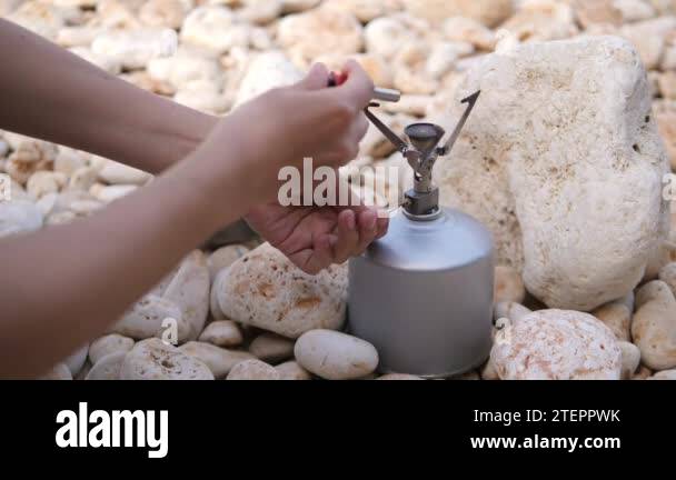 Young Hiker Woman Lights Gas burner Stove. Cooking Food Outside ...