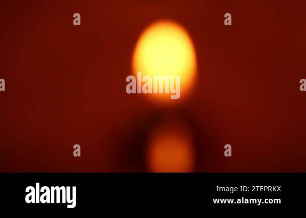 Animation based on a blurry round candle flame flickery flare on dark ...
