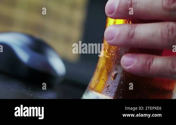 man drink fresh beer with foam in front of mouse and pc keyboard ...