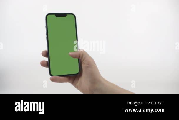 Woman Holds Smartphone with Green Screen Vertically and Swipes Pictures ...