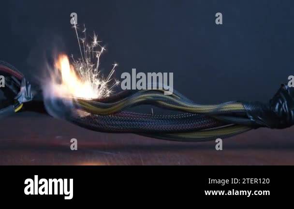The wiring is burning and sparking on a dark background. A short ...