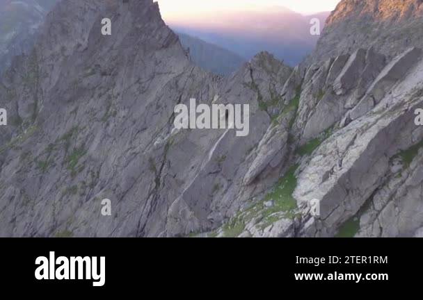 Drone view flying toward jagged ridgeline high in mountains of Romania ...