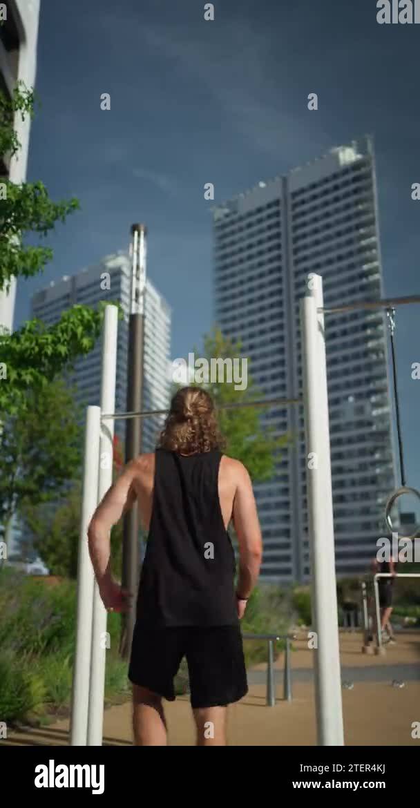 Young sportsman doing pulls ups on the horizontal bar street gym. Male ...