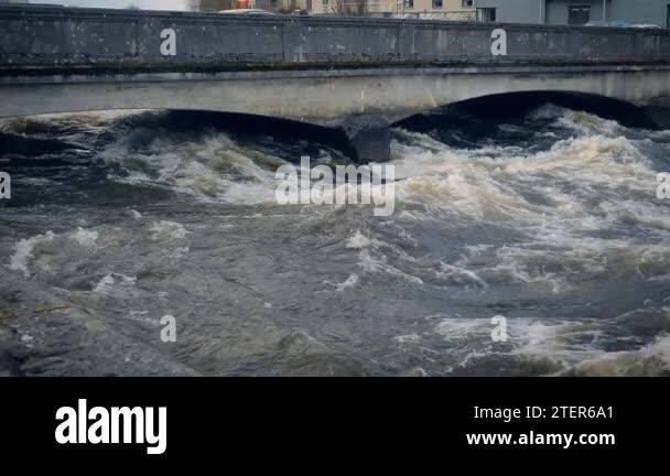 Rain swollen River Corrib rushing and churning under a bridge in Galway ...