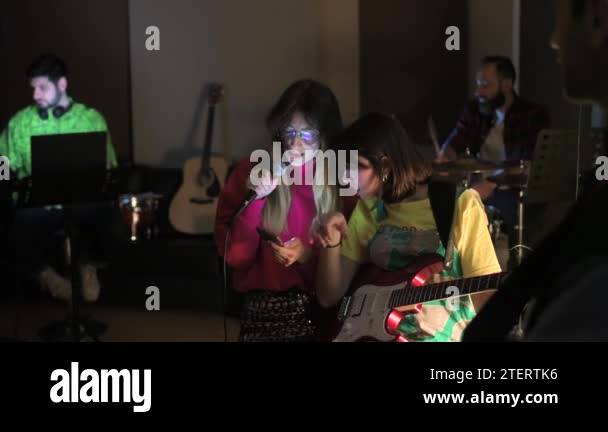 Women guitarist and singer using smartphone indoor recording studio ...