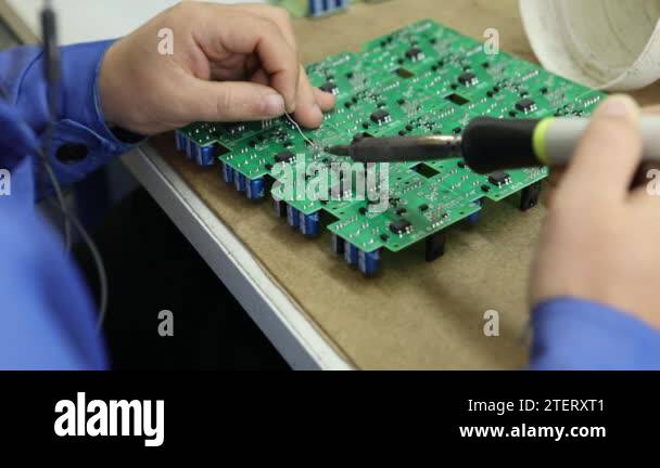 A man collects radio components. He puts it on the board and soldering ...