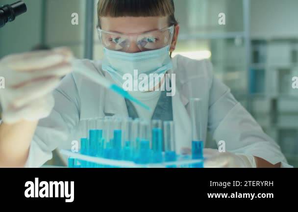 Female microbiology scientist in protective face mask, glasses and ...