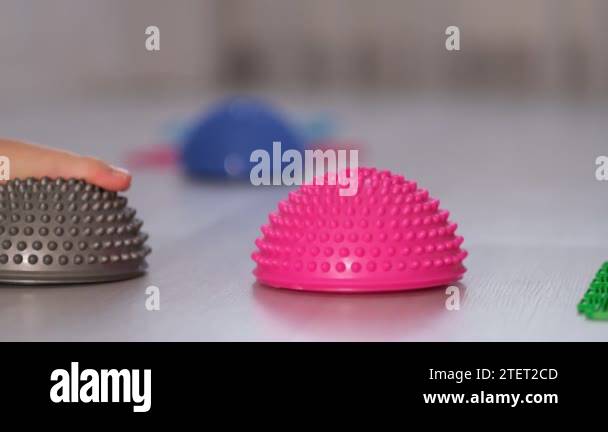 Little boy steps on orthopedic massage mats with different stiffness ...