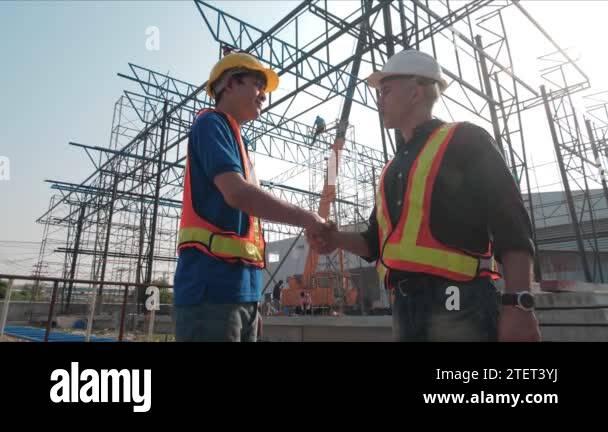 Engineer man handshake with Asian business in construction site ...