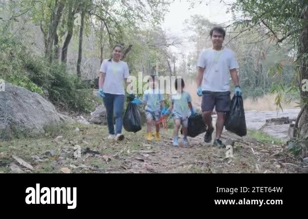 A group of Asian volunteer families give their thumbs up after ...