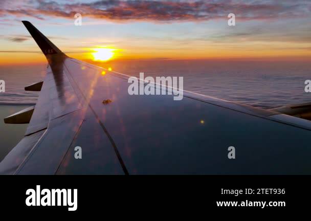 Airplane flying. Wing of an airplane flying above the clouds with ...