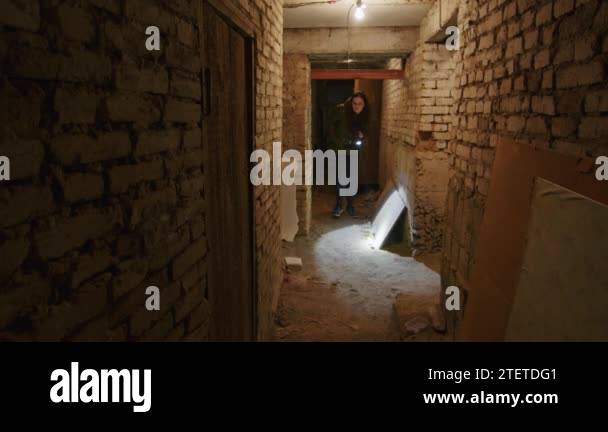 a girl in a terrible state searches a scary basement to find a possible ...