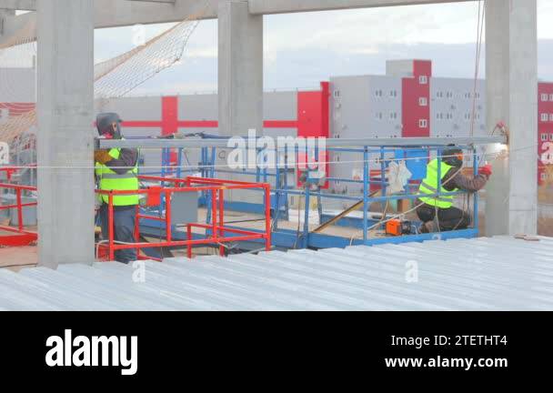 Welders at the construction site. Builders perform welding work. A man ...