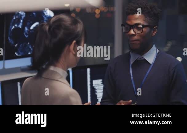 Over-shoulder of Asian woman and intelligent Black man standing in ...