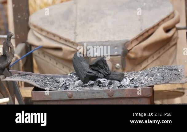 Medieval method of forging iron, the blacksmith forges an iron nail ...