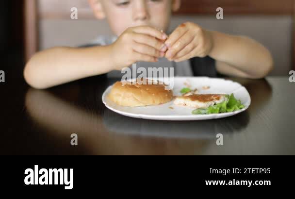 Little boy in fast food cafe eats burger. little kid eating burger ...