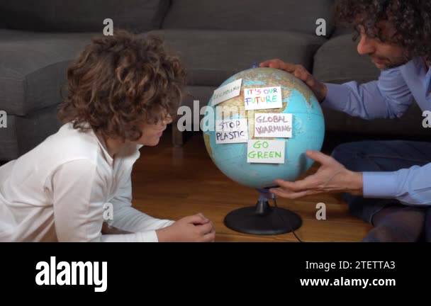 Boy with Father and Earth globe with stickers with the message Save the ...