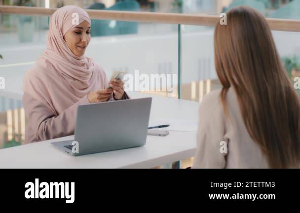Young friendly smiling arab woman manager sits in office at desk ...