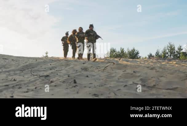 Military men in uniform on mission, coming down from observation post ...