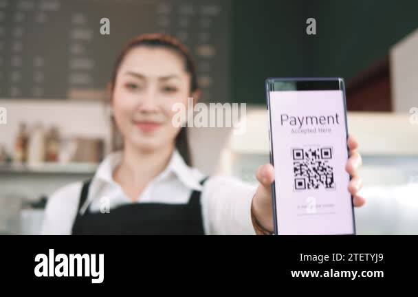 Portrait of Asian woman barista showing payment by scanning QR code on ...