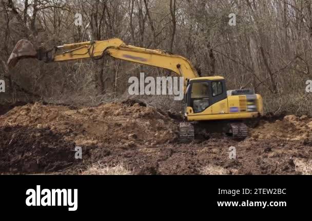 Working with backhoe by digging ground at construction site. Excavator ...