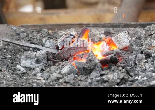 Medieval method of forging iron, the blacksmith forges an iron nail ...