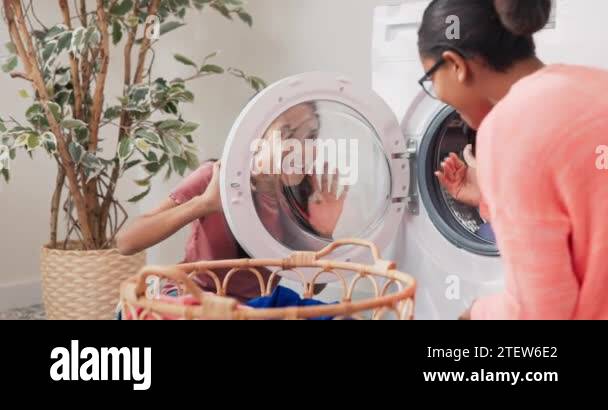 Fooling around, joking, playing while doing household chores, woman and ...