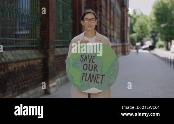 Single female eco activist standing and holding banner save our planet ...