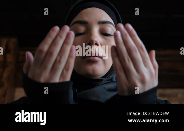 Young Muslim woman in hijab praying namaz. Close-up pray midle east ...