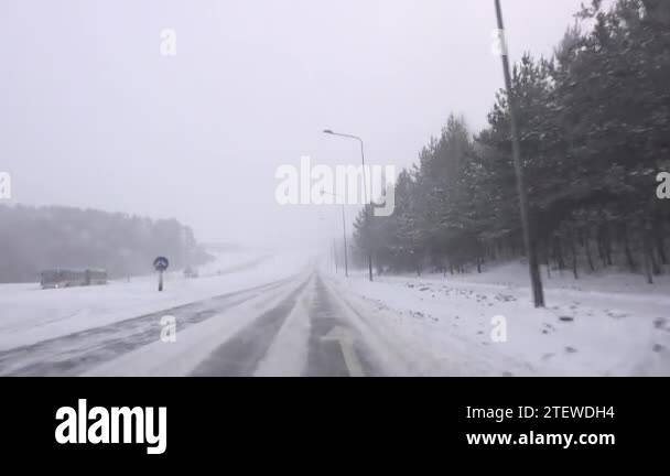 Blurry dangerous car driving conditions on highway at heavy snow fall ...