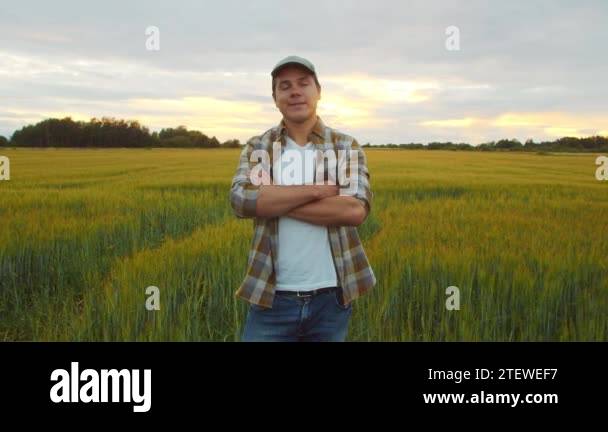 Farmer in front of a sunset agricultural landscape. Man in a ...