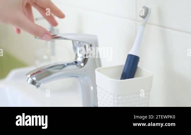 Woman uses new modern ultrasonic toothbrush in bathroom at home. Oral ...