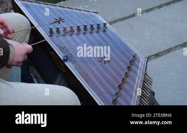 A musician plays the cymbals. A man quickly strikes the strings with ...